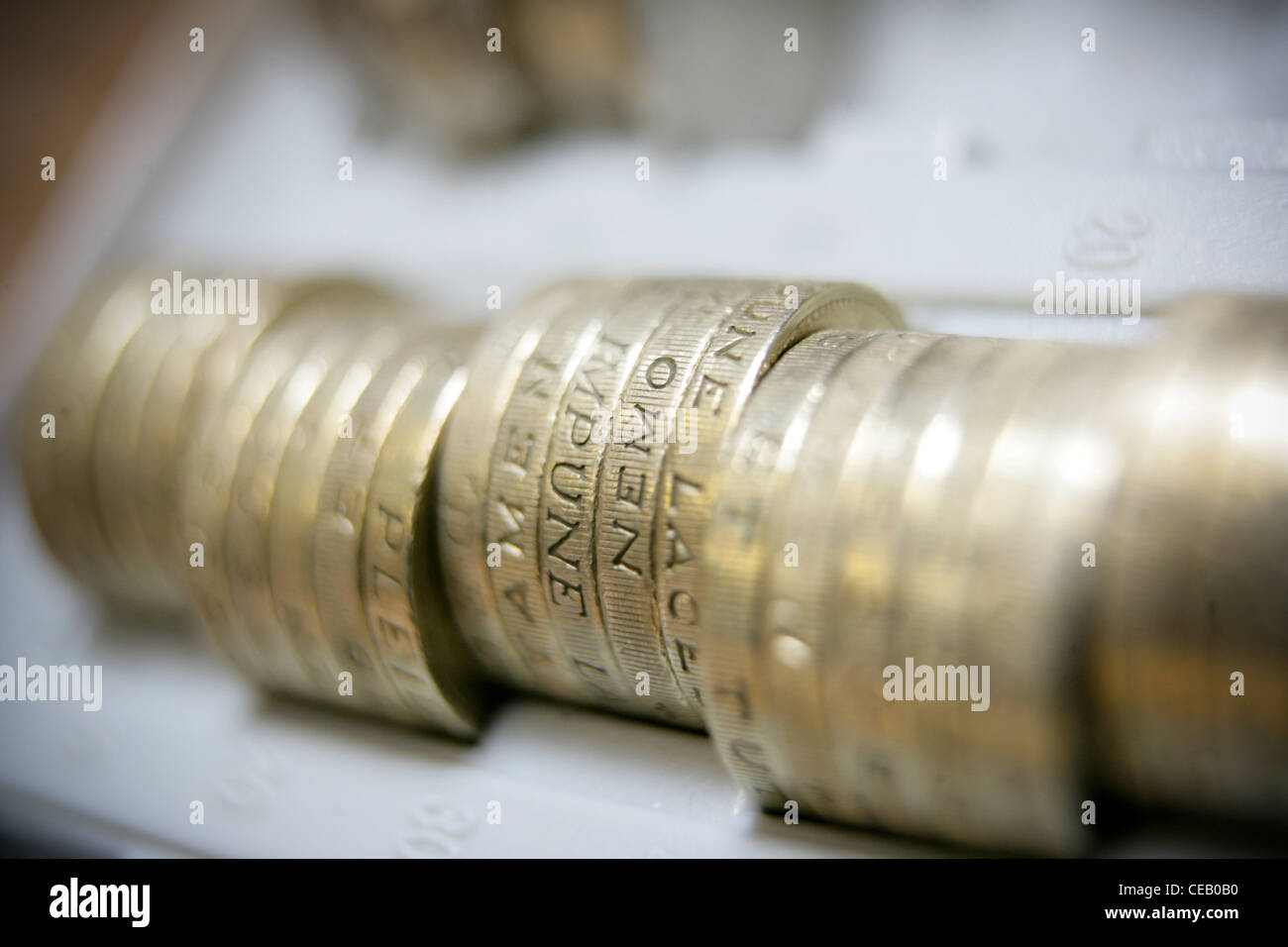A stack of one pound coins in a container Stock Photo - Alamy