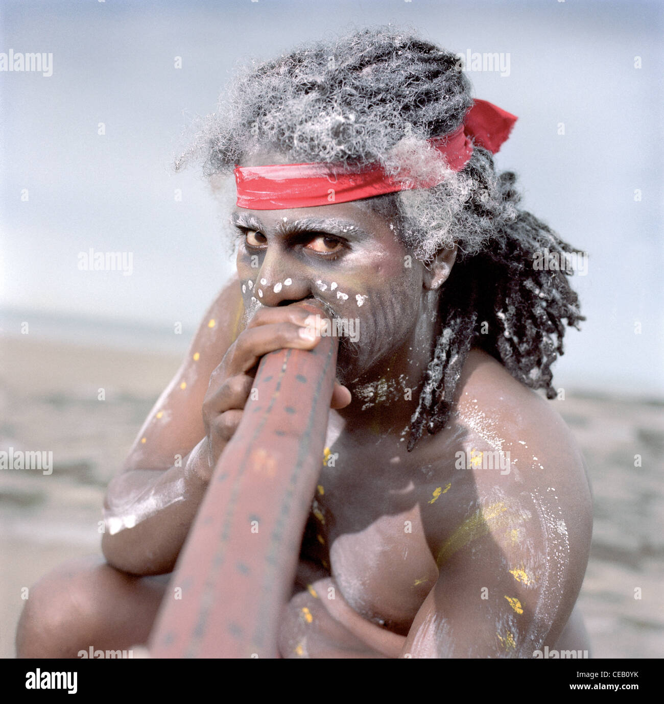 Aboriginal man playing a didgeridoo on a beach Stock Photo - Alamy