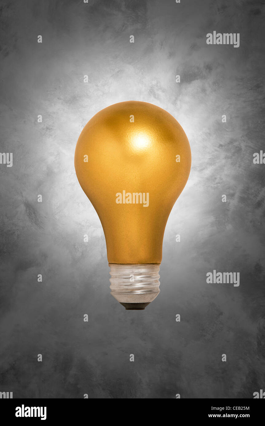 Gold light bulb floating against a gray mottled background Stock Photo ...