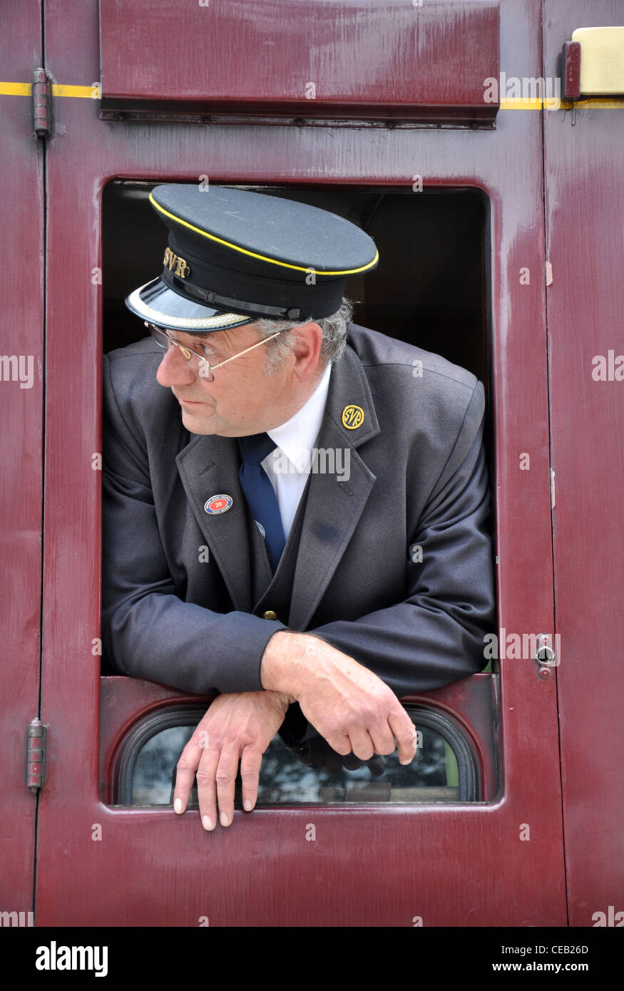 Steam train conductor leaning out of passenger car window Stock Photo ...