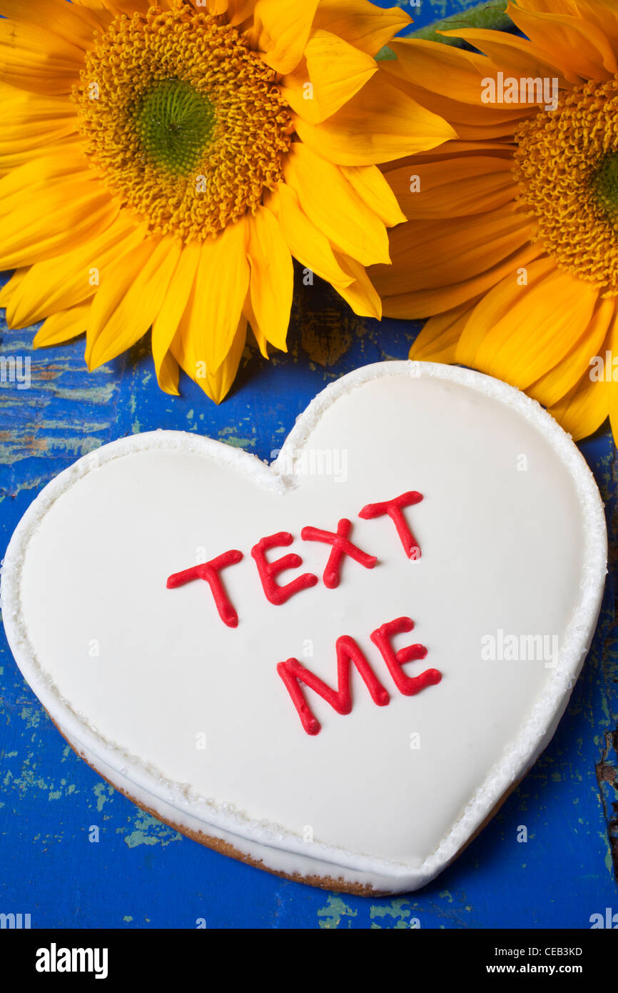 Text Me heart shaped cookie and sunflowers Stock Photo - Alamy