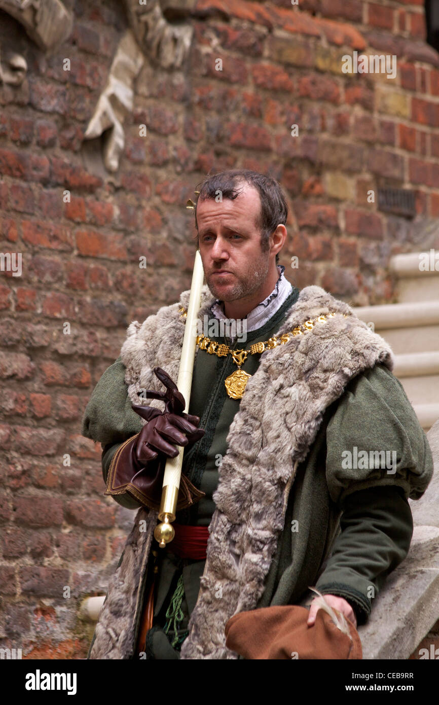 An actor wears traditional Tudor dress including fur cloak and gold ...