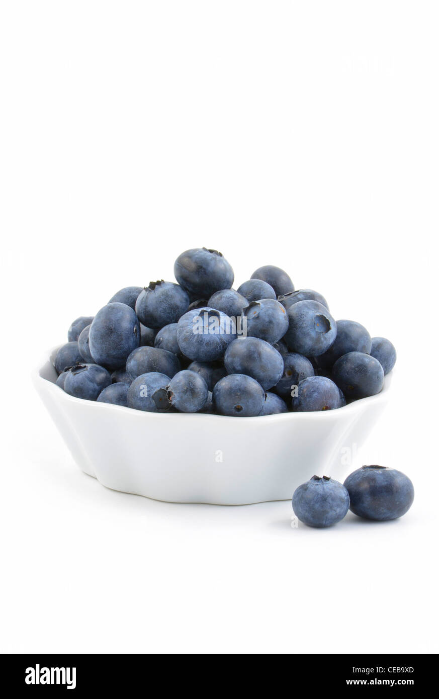 Fresh washed blueberries in small white dish, vertical format with room ...