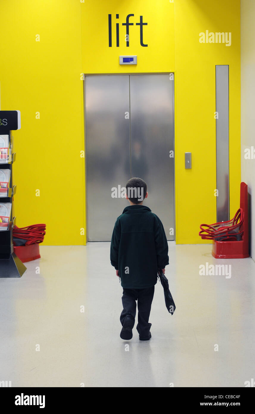 young boy waiting for a lift,architecture, brushed, close, closed doors ...