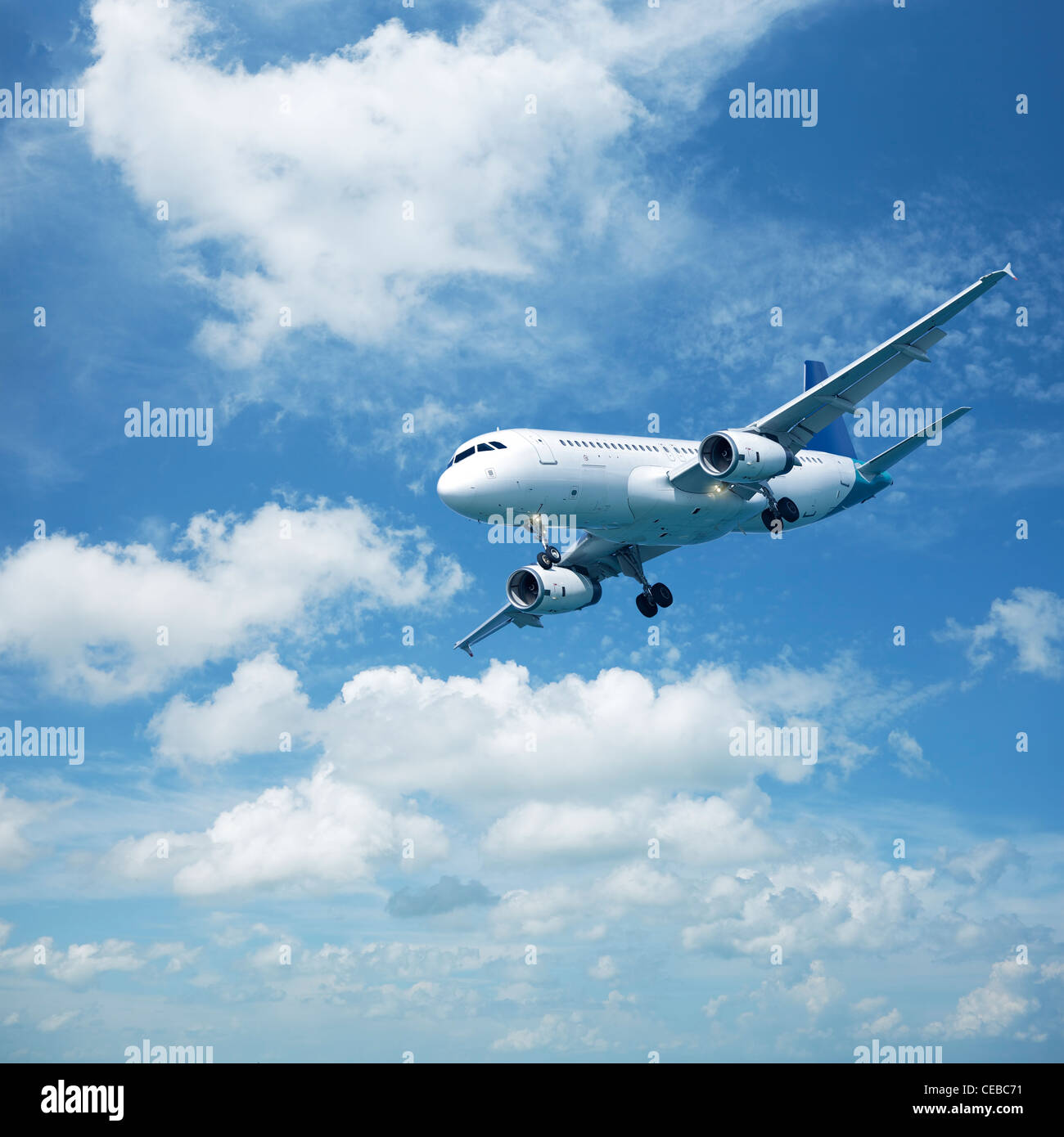 Jet plane in a blue cloudy sky. Square composition Stock Photo - Alamy