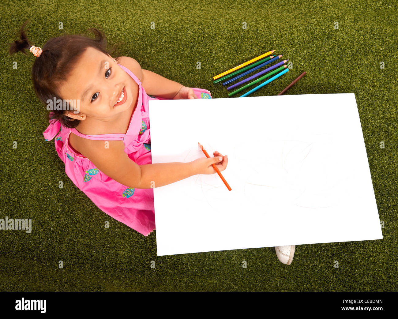 Child Sitting On The Grass Drawing A Picture With Multi Colorored ...