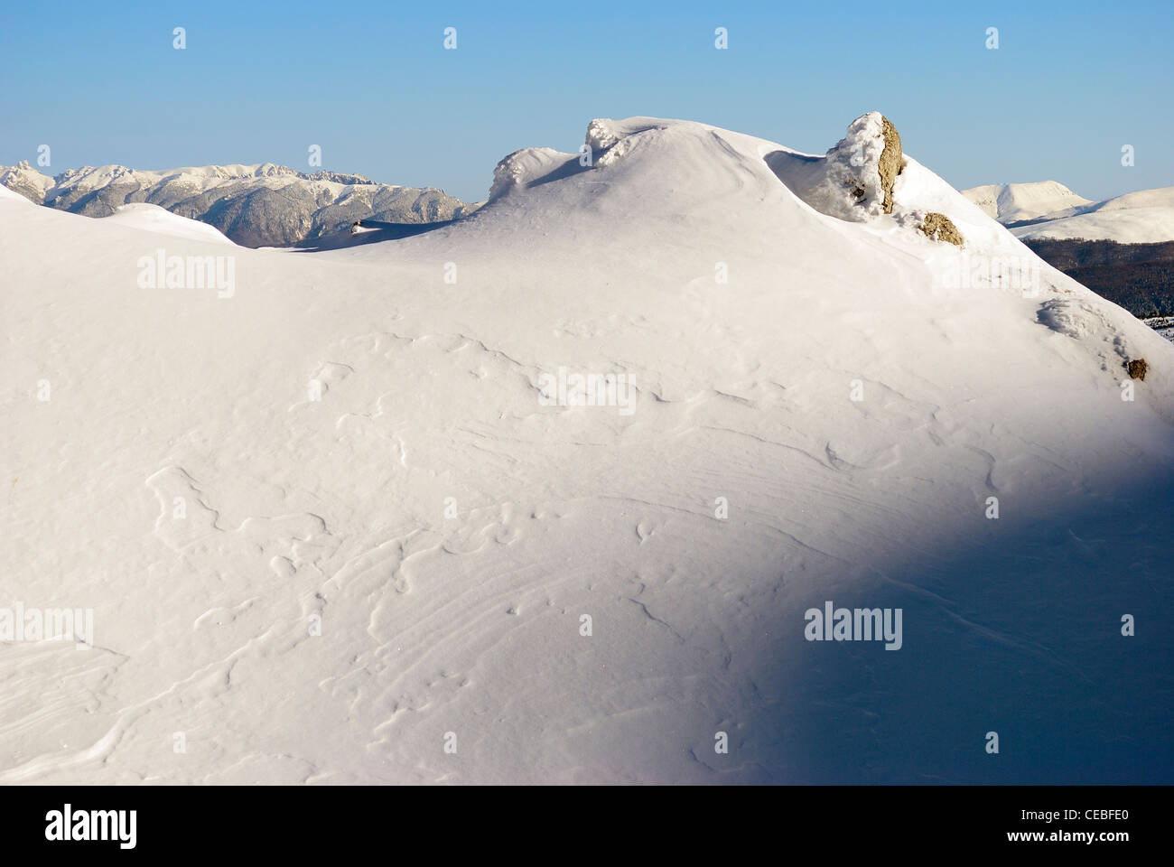 Snowy hill with mountains in the background Stock Photo - Alamy