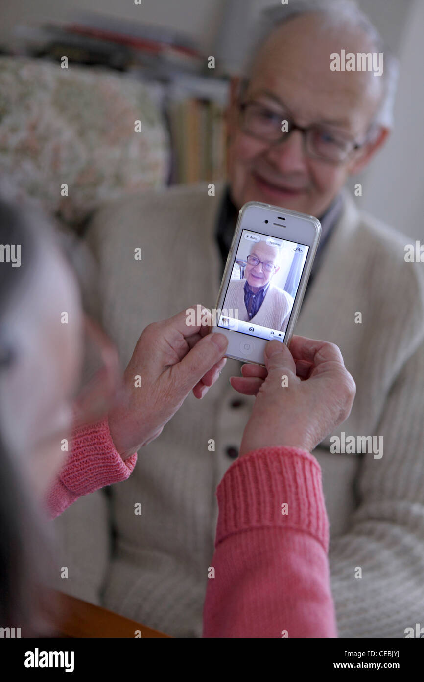 elderly couple use iPhone to take family photographs, enjoying user ...