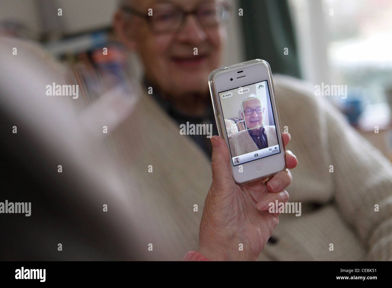 elderly couple use iPhone to take family photographs, enjoying user ...