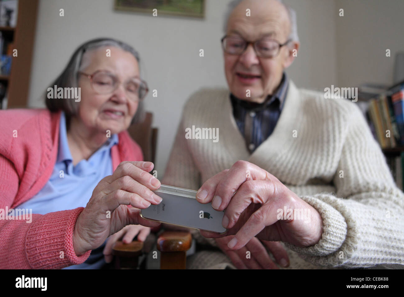 Older elderly couple sharing adopting new technology, iPhone 4 ...