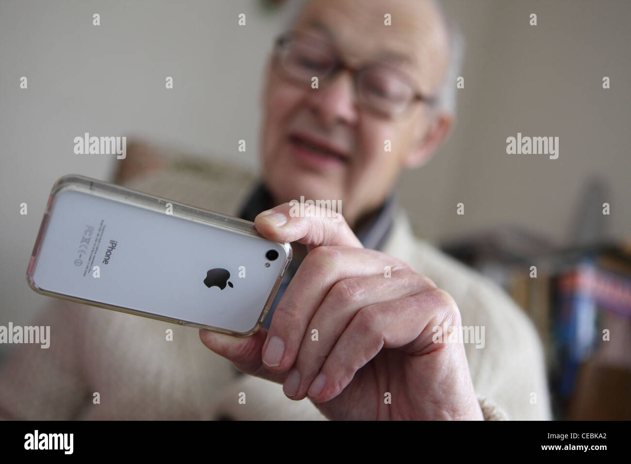 Elderly man adopting new technology, touchscreen iPhone, Smartphone, at ...