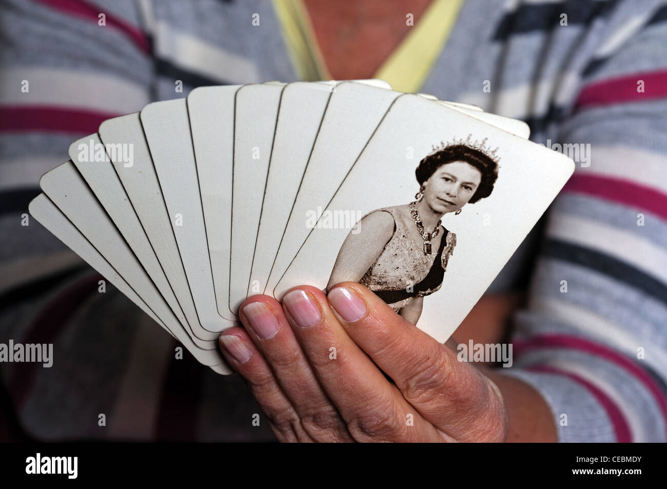 Woman holding Queen Elizabeth II silver jubilee playing cards, England ...
