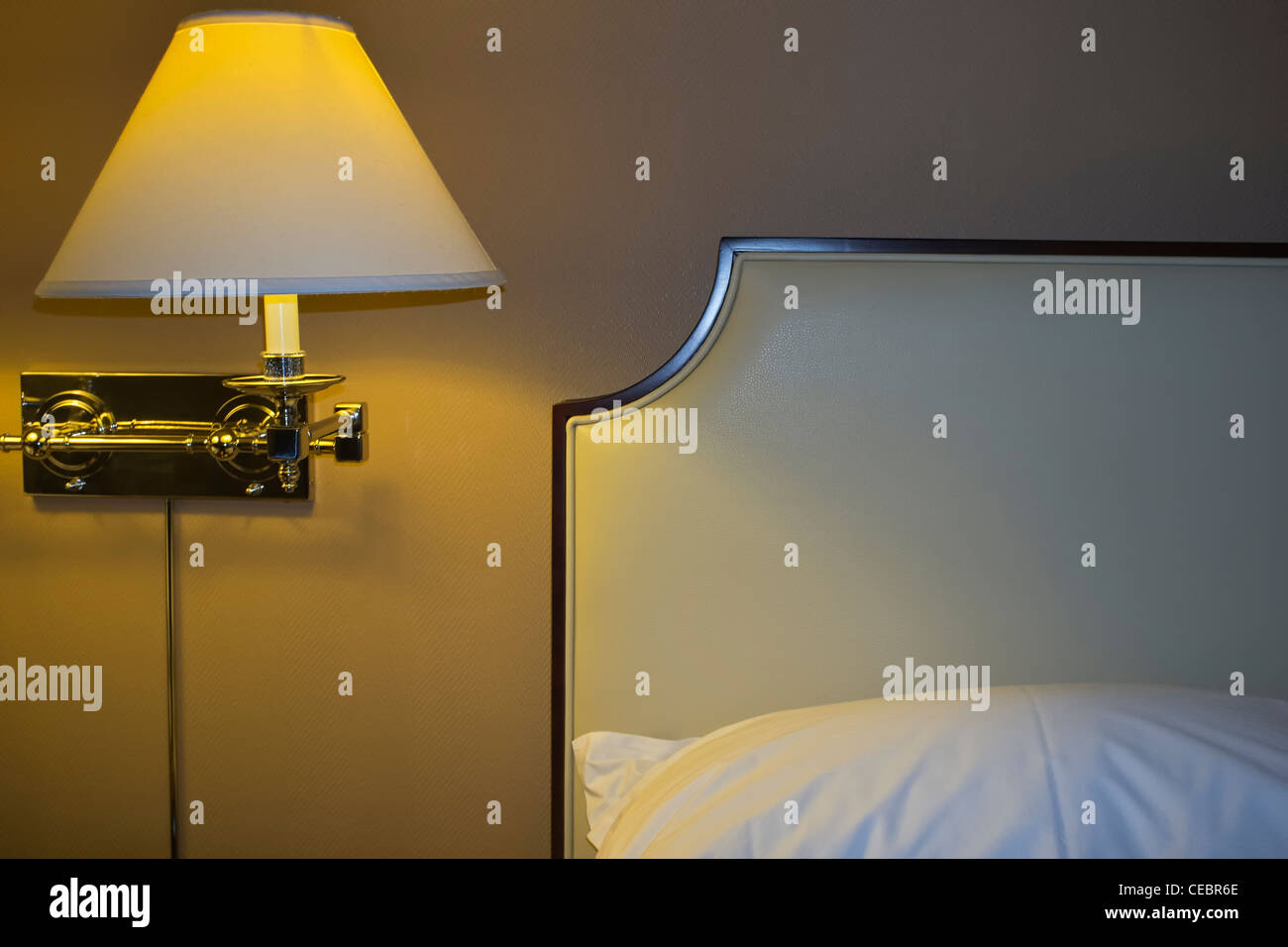 Hotel room lamp shade next to bed Stock Photo - Alamy
