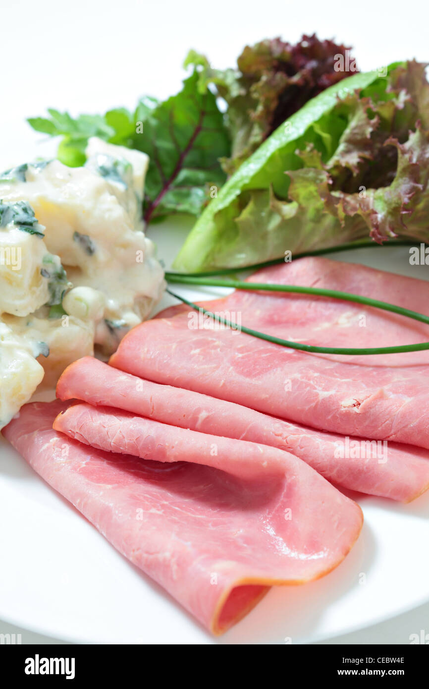 Slices of smoked beef ham served with potato salad and garden fresh ...
