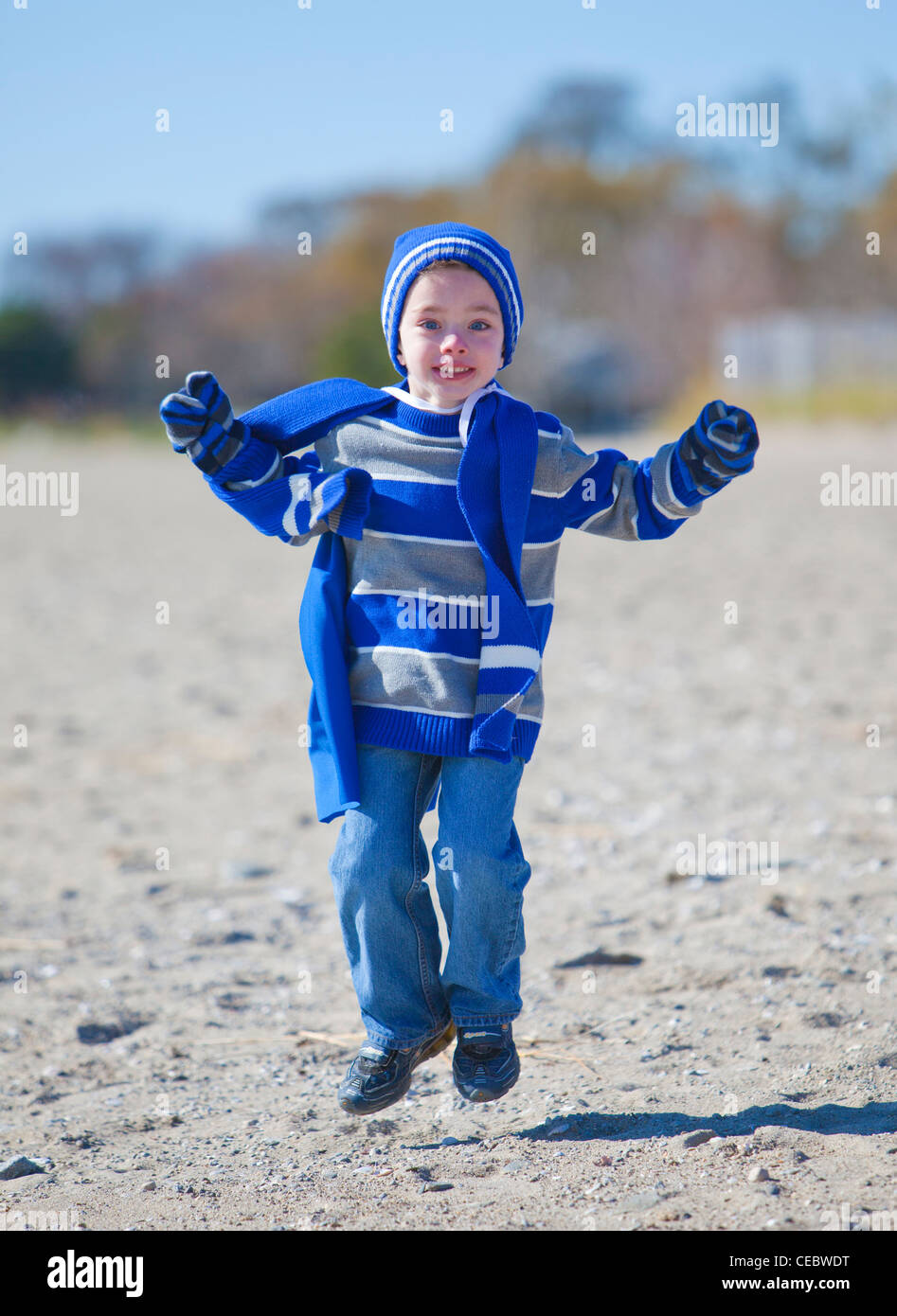 Young boy at the beach wearing winter clothing Stock Photo - Alamy