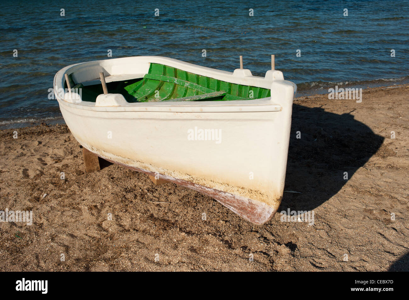 Small white fishing boat on a beach Stock Photo - Alamy