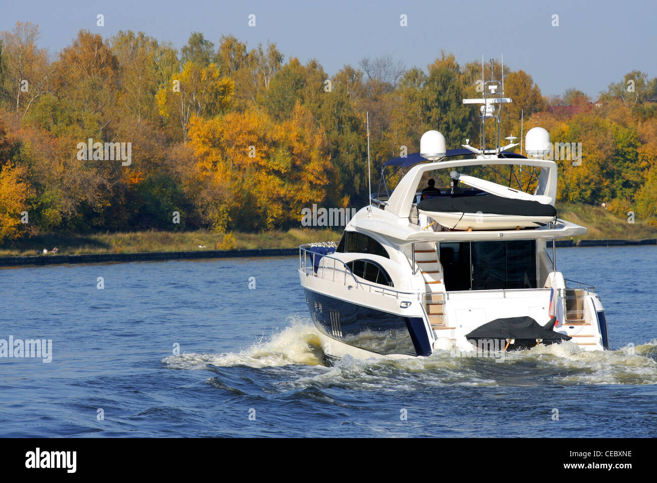 Rear view of sailing luxury yacht on golden autumn scenic background ...