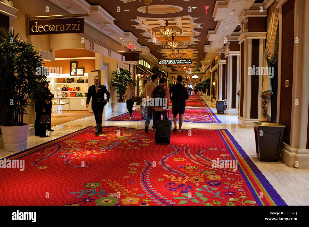 People walk through an elegant hall lined with shops inside the Wynn ...