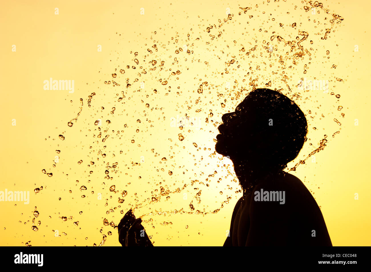 Indian man splashing water over himself at sunset. Silhouette. India ...