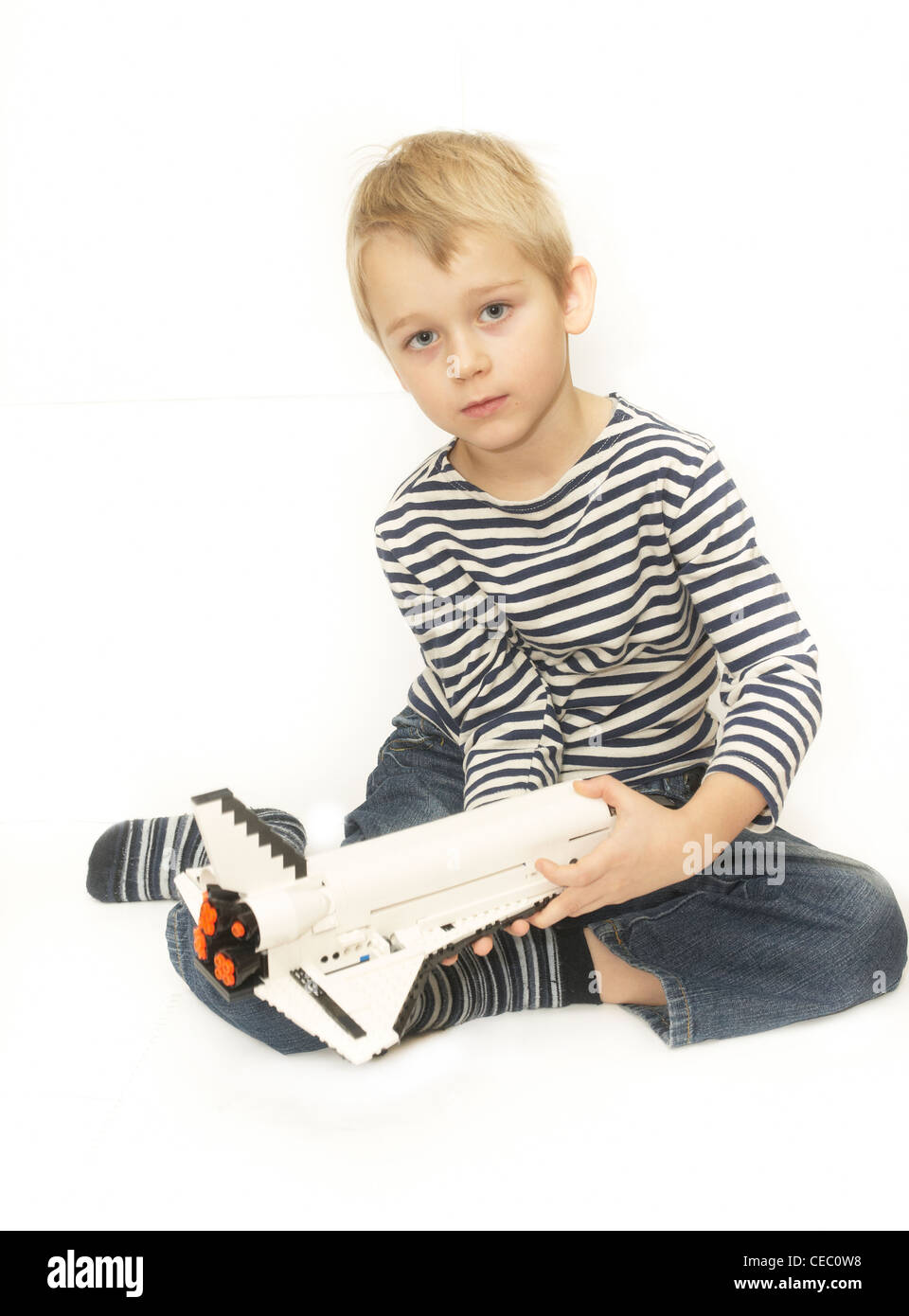 Child blond boy playing with Lego Space Shuttle model toy cut out Stock ...