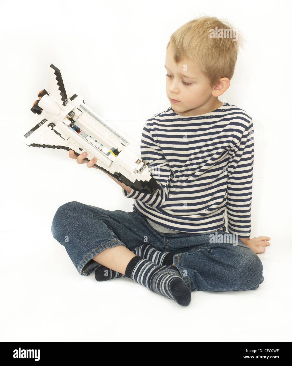 Child blond boy playing with Lego Space Shuttle model toy cut out Stock ...