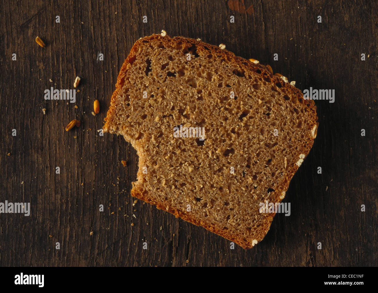 Slice of bread missing bite and crumbs on wood surface Stock Photo - Alamy