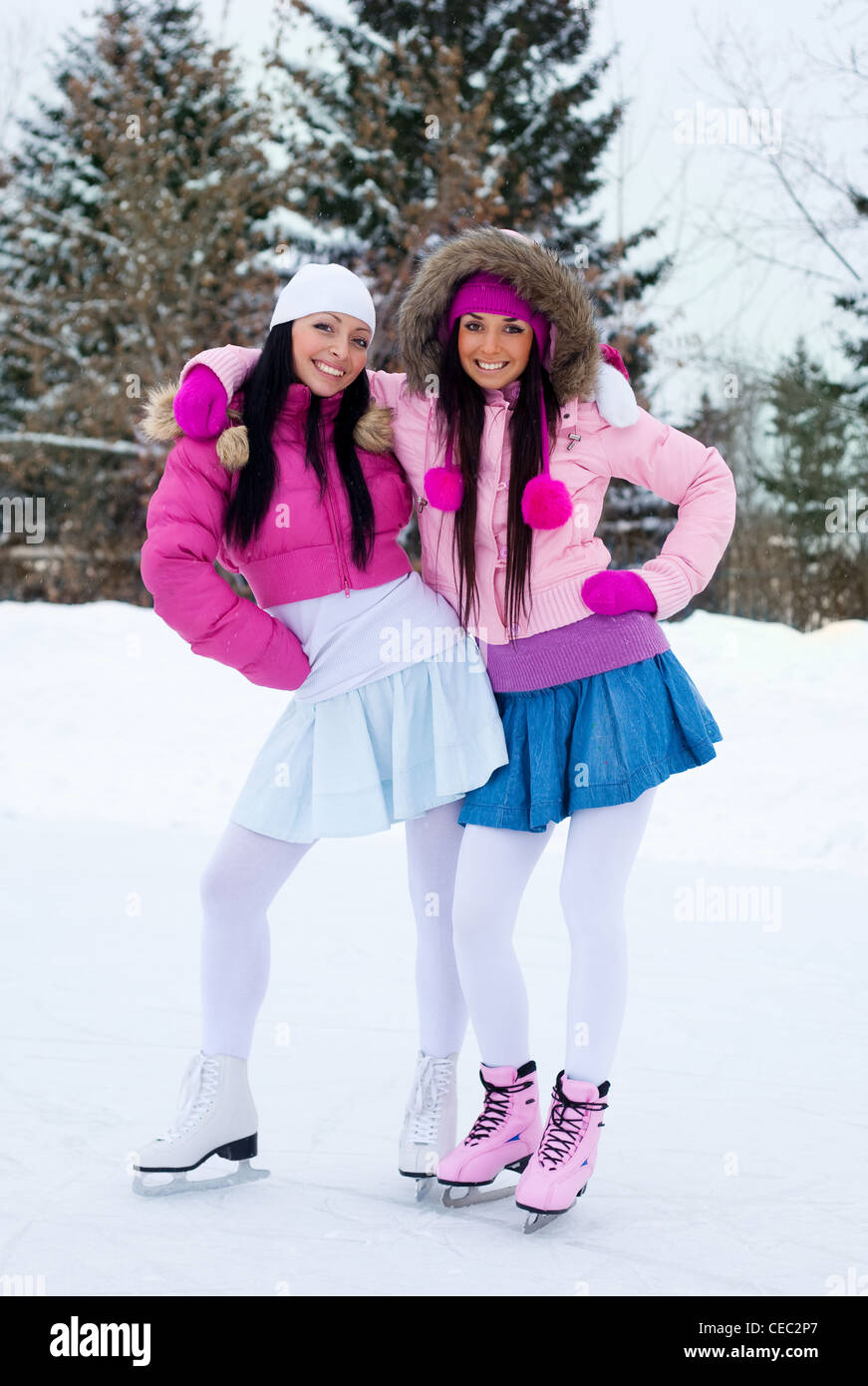two happy young women ice skating on a winter day Stock Photo - Alamy
