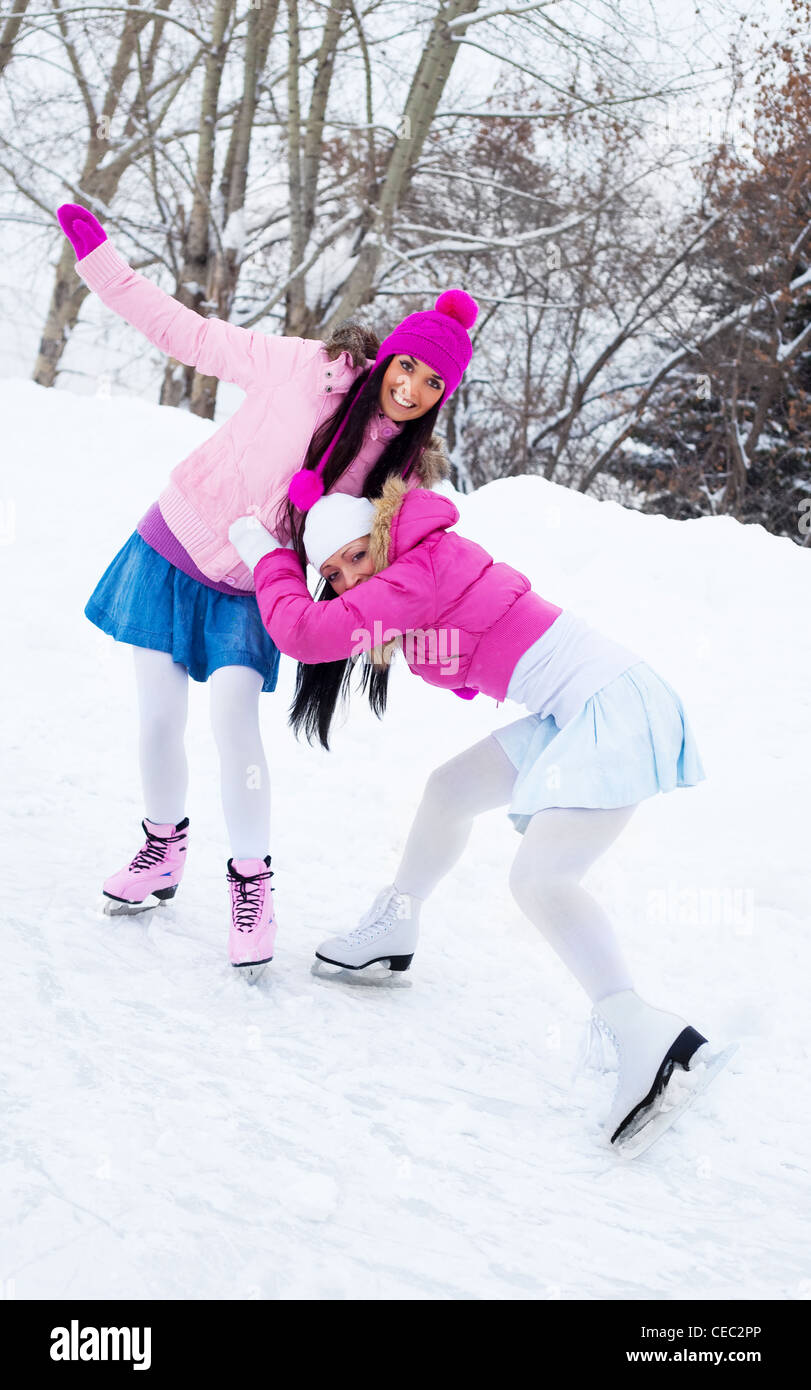 two happy young women ice skating on a winter day Stock Photo - Alamy
