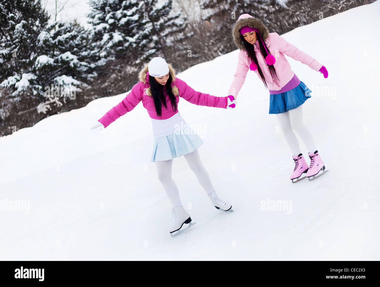 two happy young women ice skating on a winter day Stock Photo - Alamy