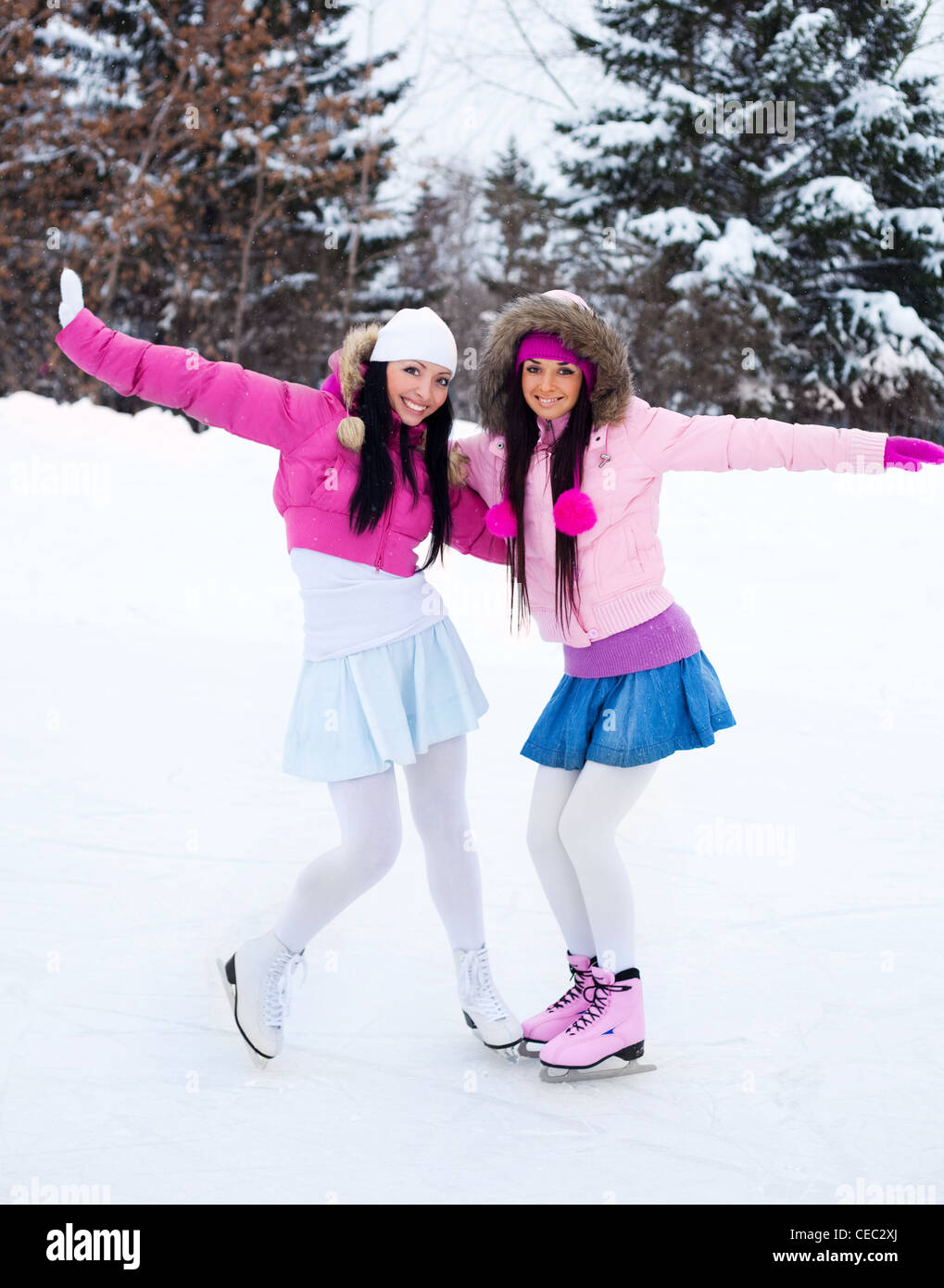 two happy young women ice skating on a winter day Stock Photo - Alamy