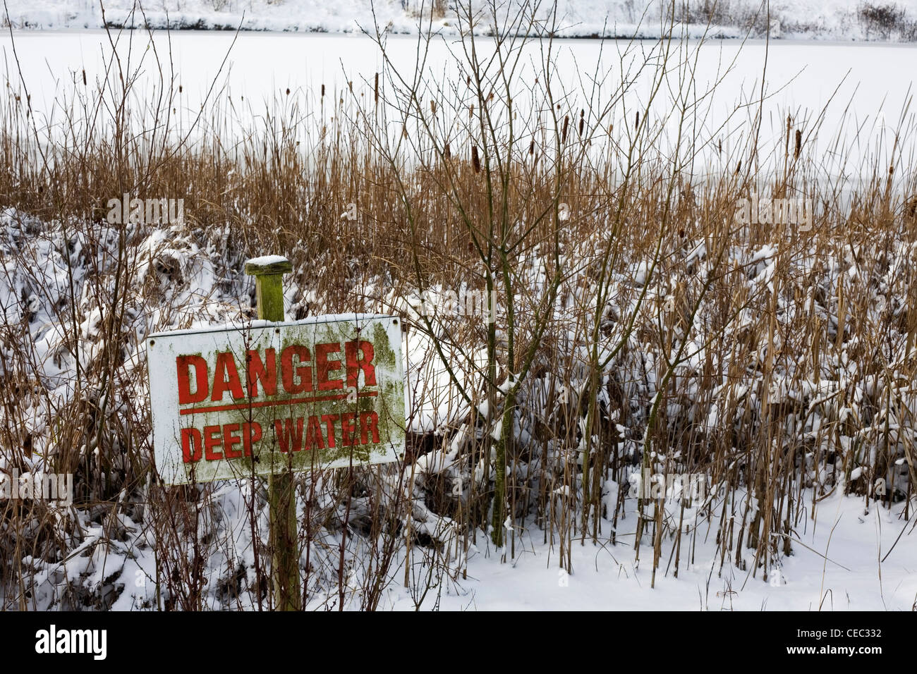Danger deep water sign next to frozen pond in snow Stock Photo - Alamy