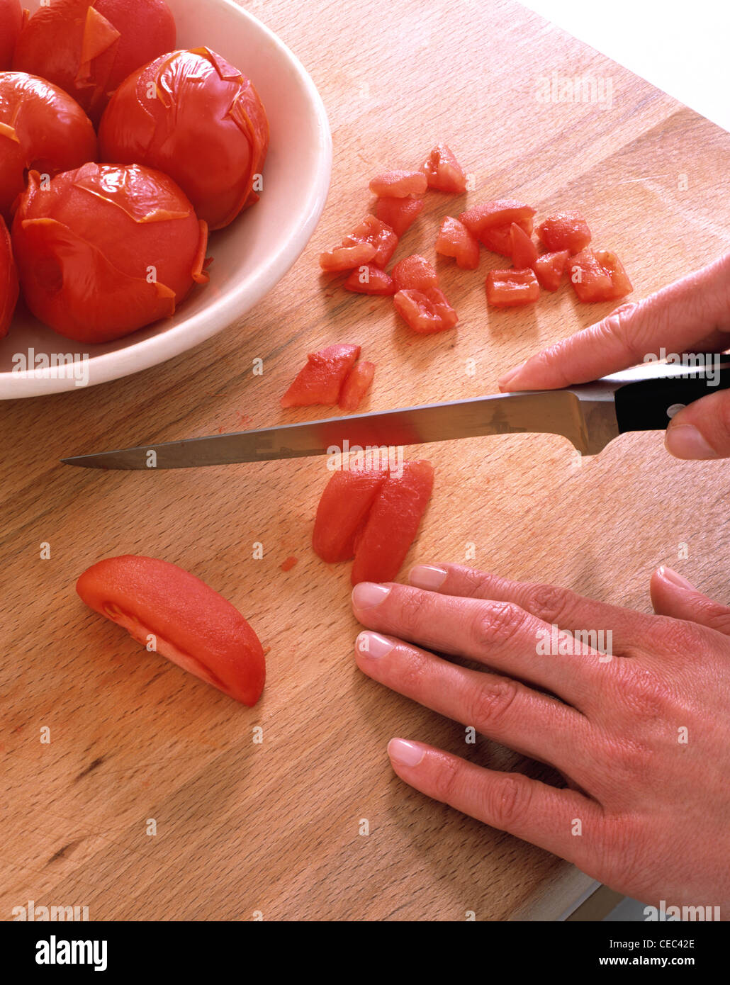 Cutting peeled tomatoes into cubes Stock Photo - Alamy