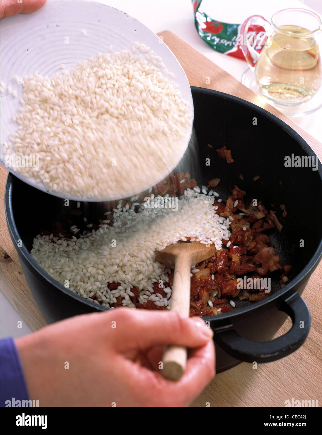 Giving risotto rice into the pan Stock Photo - Alamy