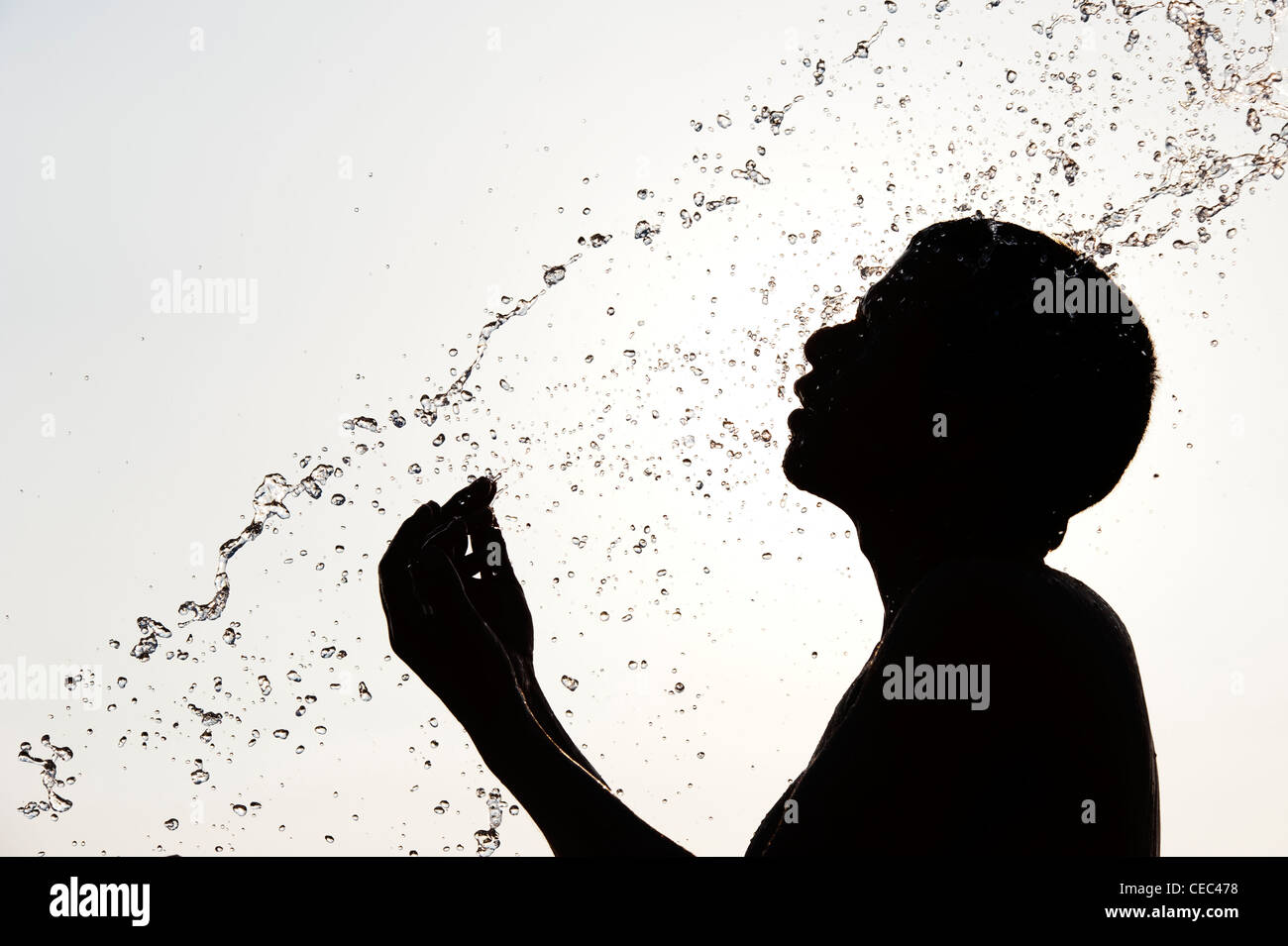 Indian man splashing water over himself. Silhouette. India Stock Photo ...