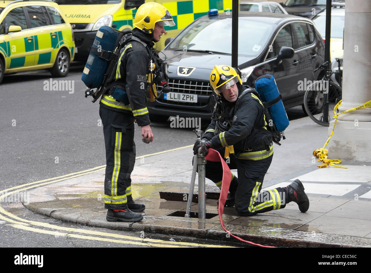 Firefighters connect a hose to a hydrant on Grafton Street Mayfair ...
