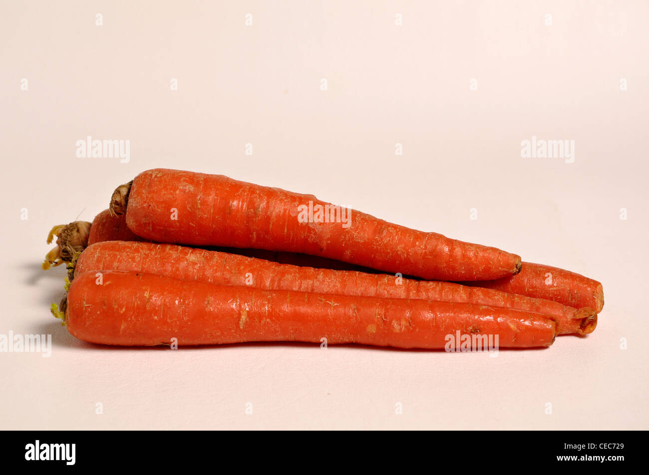 Four carrots lay on a plain white background Stock Photo - Alamy