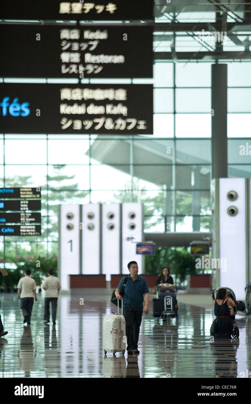 Passengers walk through the departures area of Terminal 3 at Changi ...