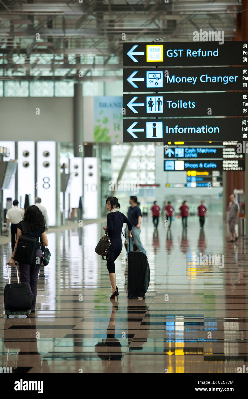 Passengers walk through the departures area of Terminal 3 at Changi ...