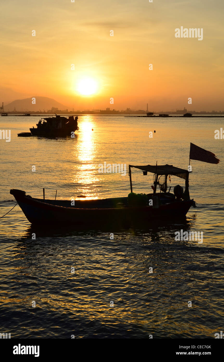 A boat floating on sea at dawn Stock Photo - Alamy