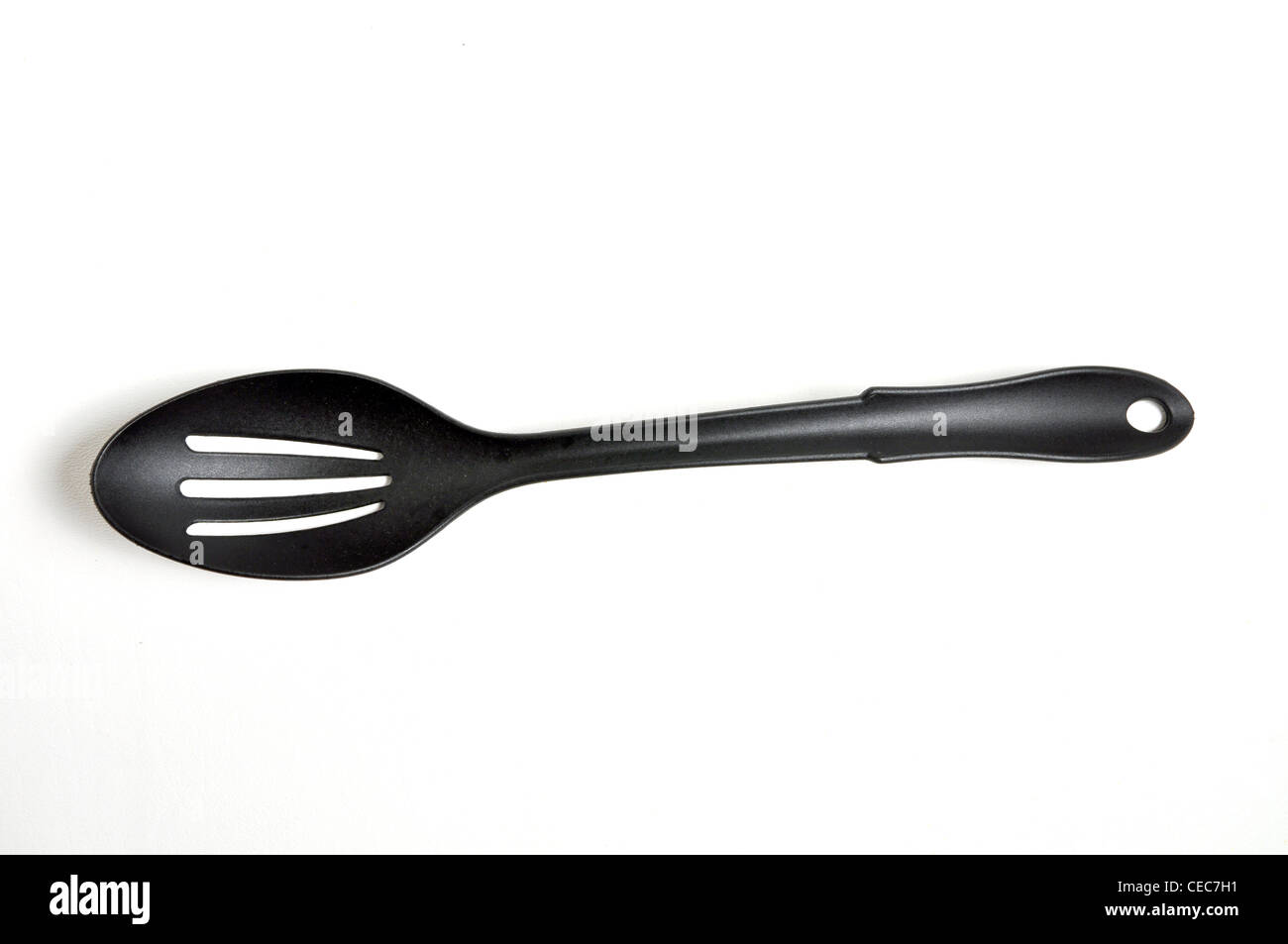 A slotted spoon is laying on a white background Stock Photo - Alamy