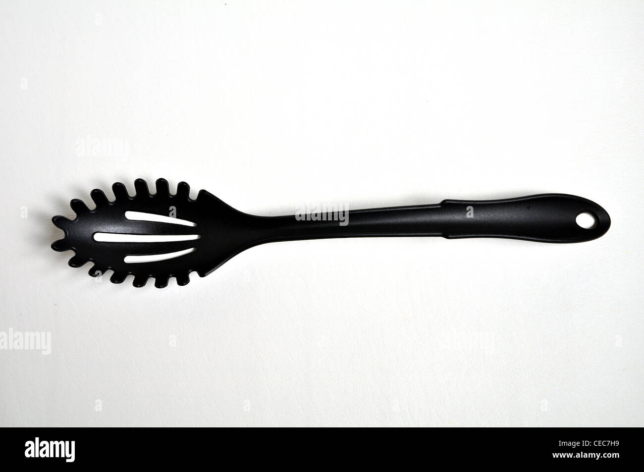 A pasta spoon is laying on a white background Stock Photo - Alamy
