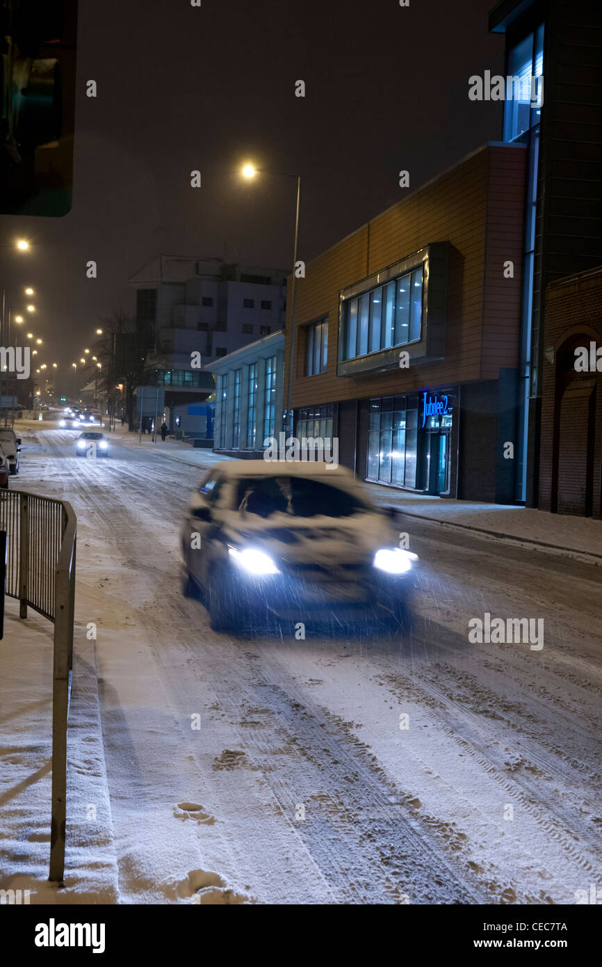 car driving down snow covered street at night Stock Photo - Alamy