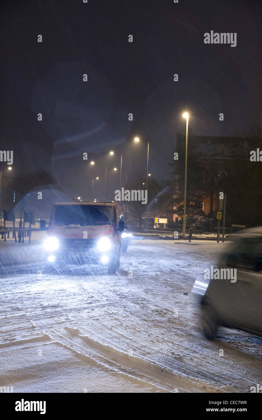 Van with lights driving around a roundabout in wintry/snowy weather at ...