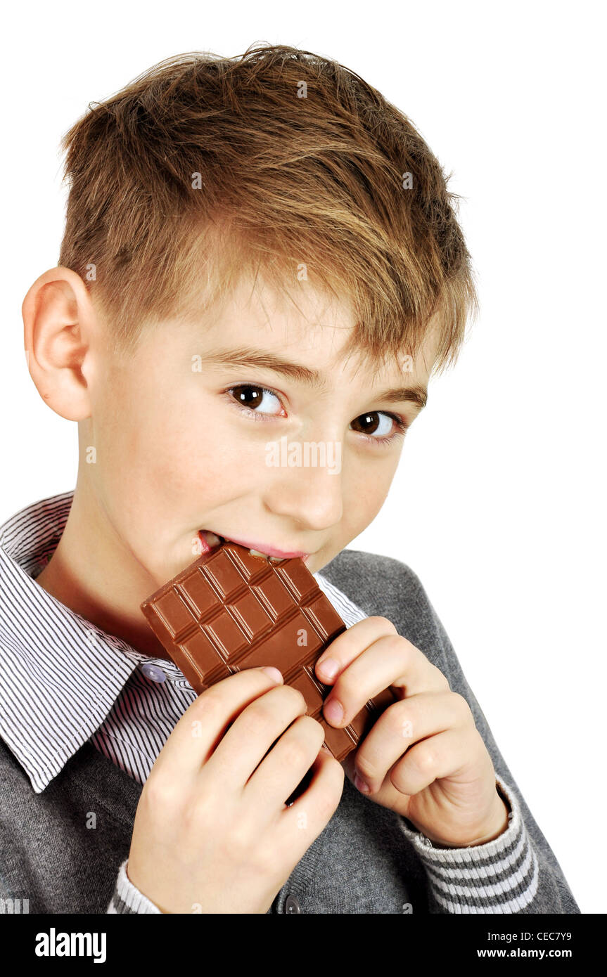 Young boy eating a chocolate bar over white background Stock Photo - Alamy