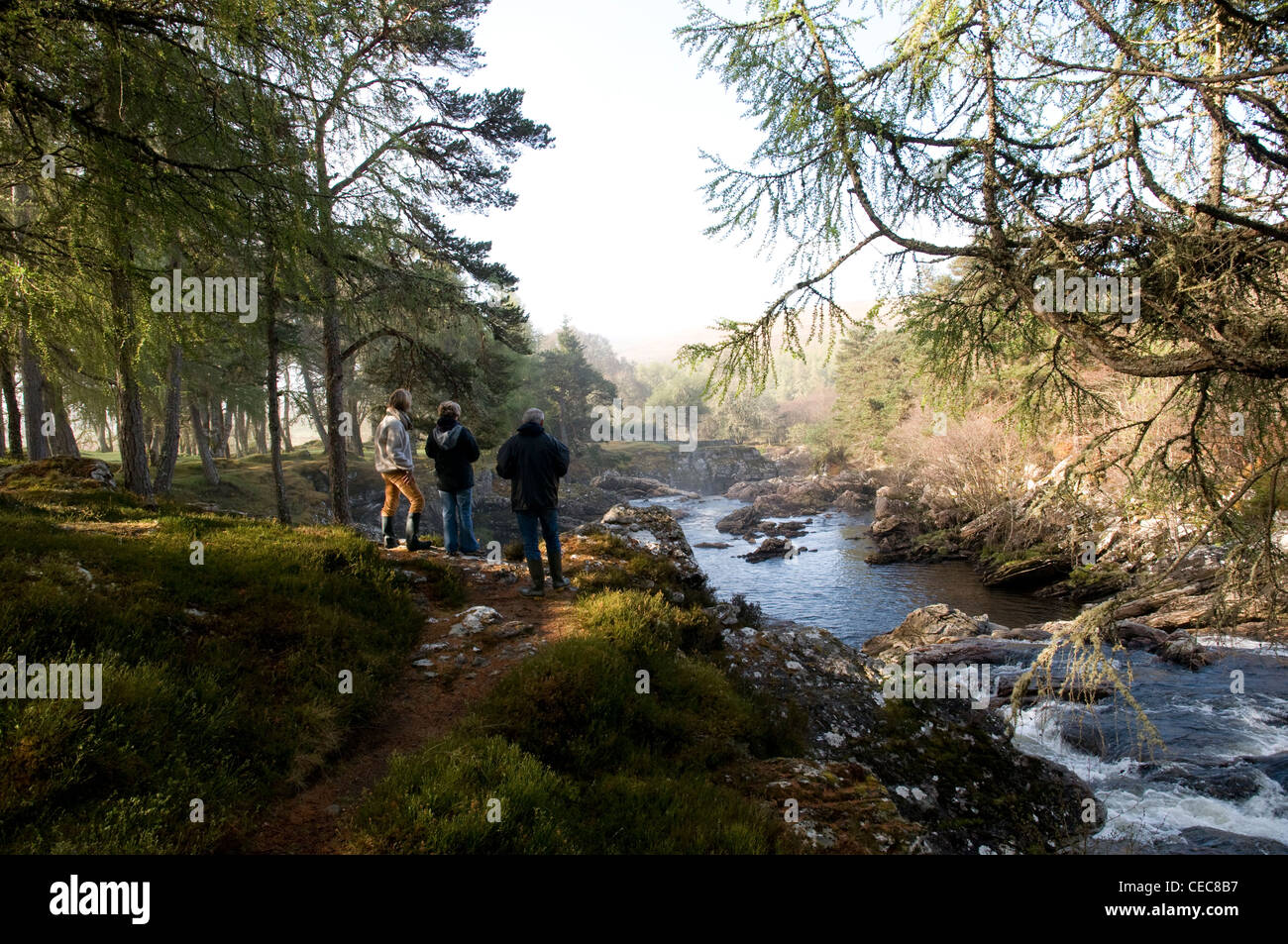 People walking along the riverbank of the River Cassley, Sutherland ...