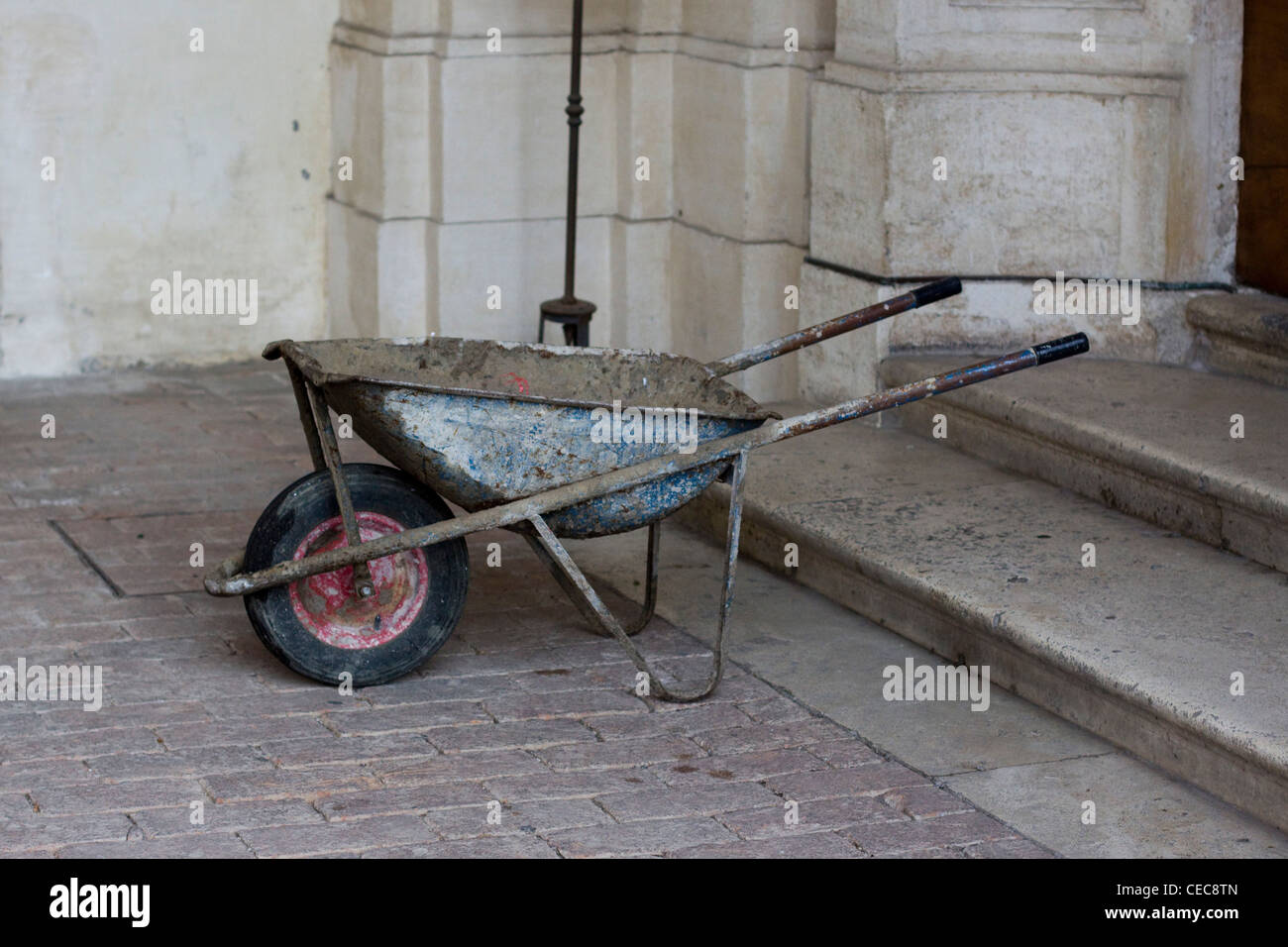 A Metal Wheelbarrow near some stone steps Stock Photo - Alamy