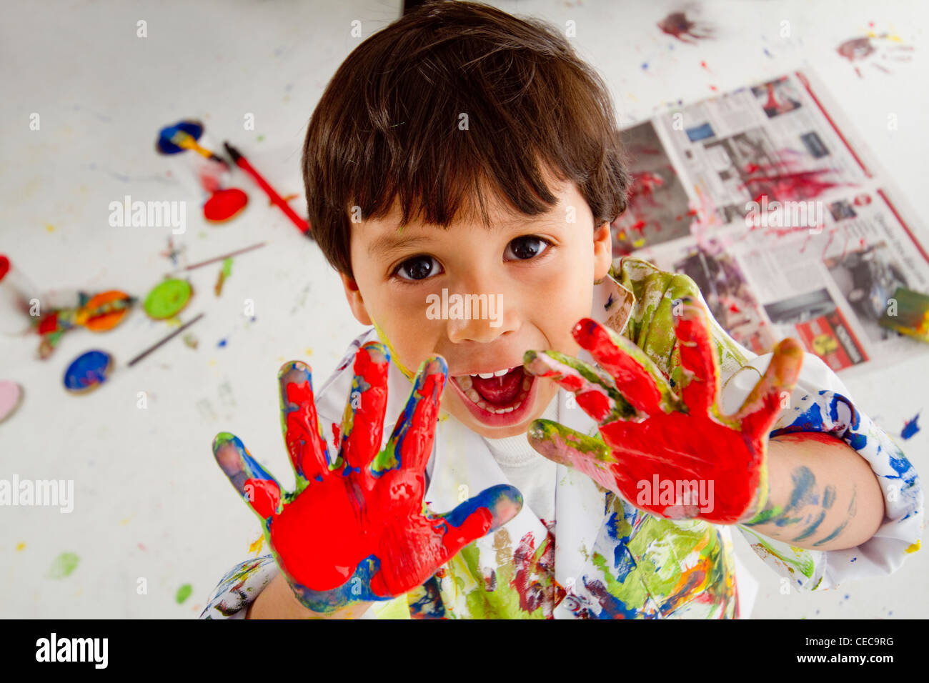 Messy Hispanic boy finger painting Stock Photo - Alamy