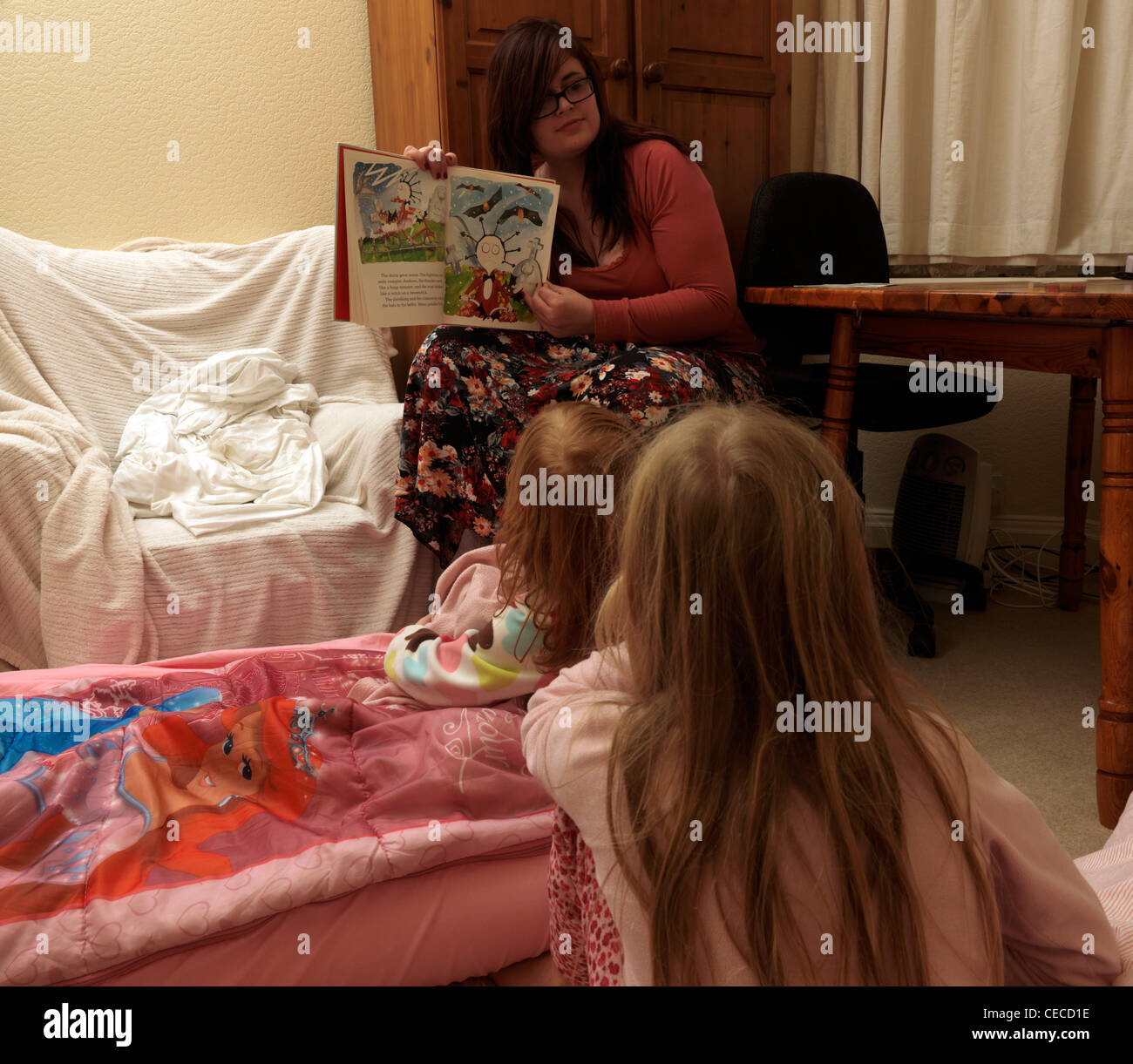 Woman Reading A Bedtime Story To Children Having A Sleepover Surrey ...