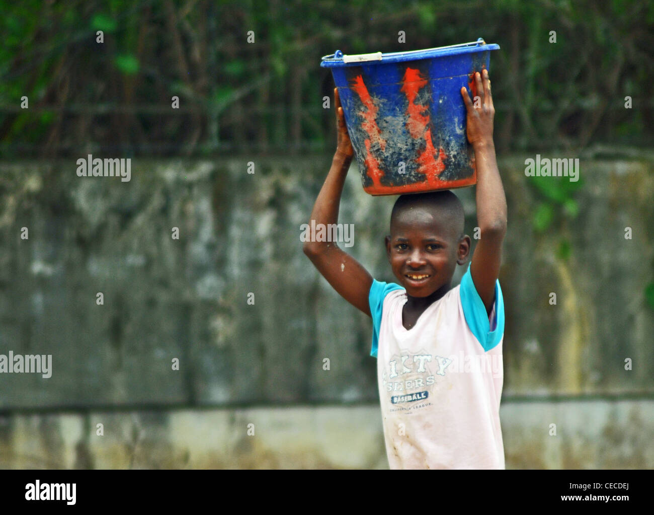 Liberian child carrying bucket in Kolahun, Liberia Stock Photo - Alamy