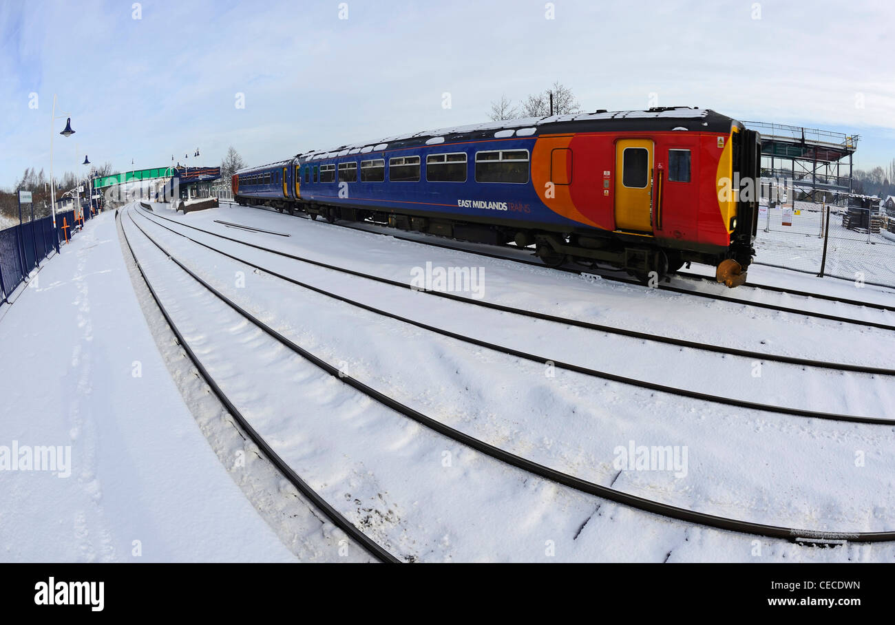 Commuter train pulling out of the local train station after a snow fall ...